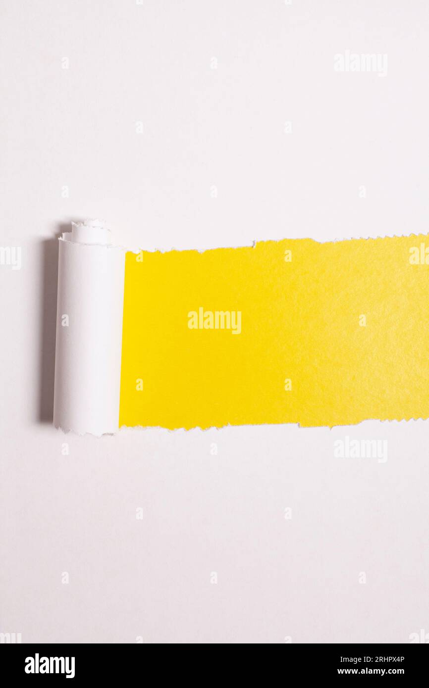 Torn paper with opening showing yellow background Stock Photo - Alamy