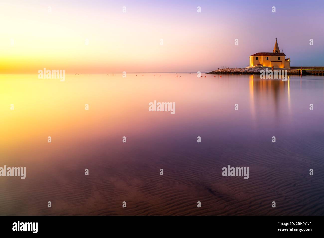 Alba sulla costa e spiaggia di Caorle, mare Adriatico. Chiesa della ...