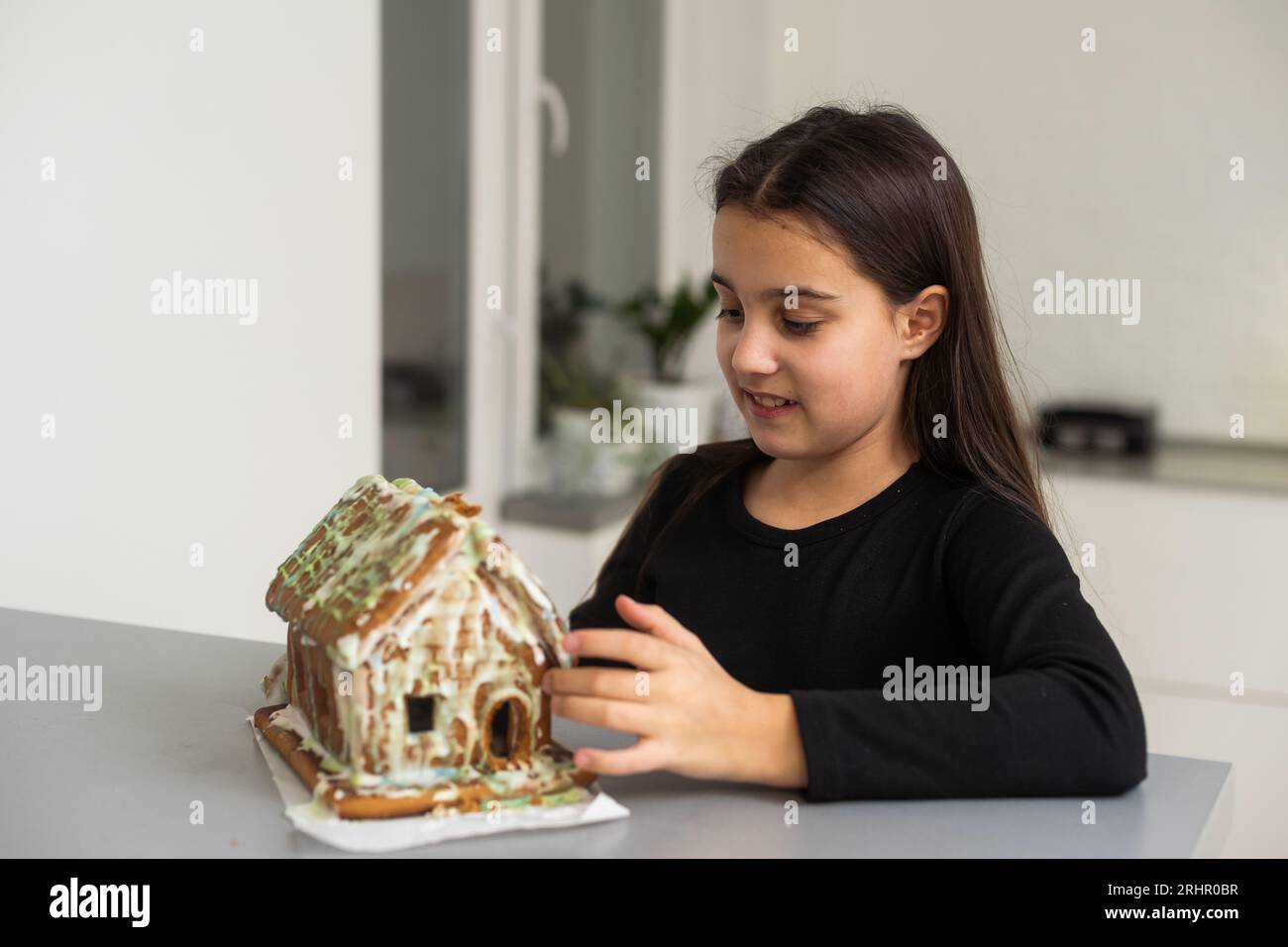A teenage girl is eating a gingerbread house Stock Photo - Alamy