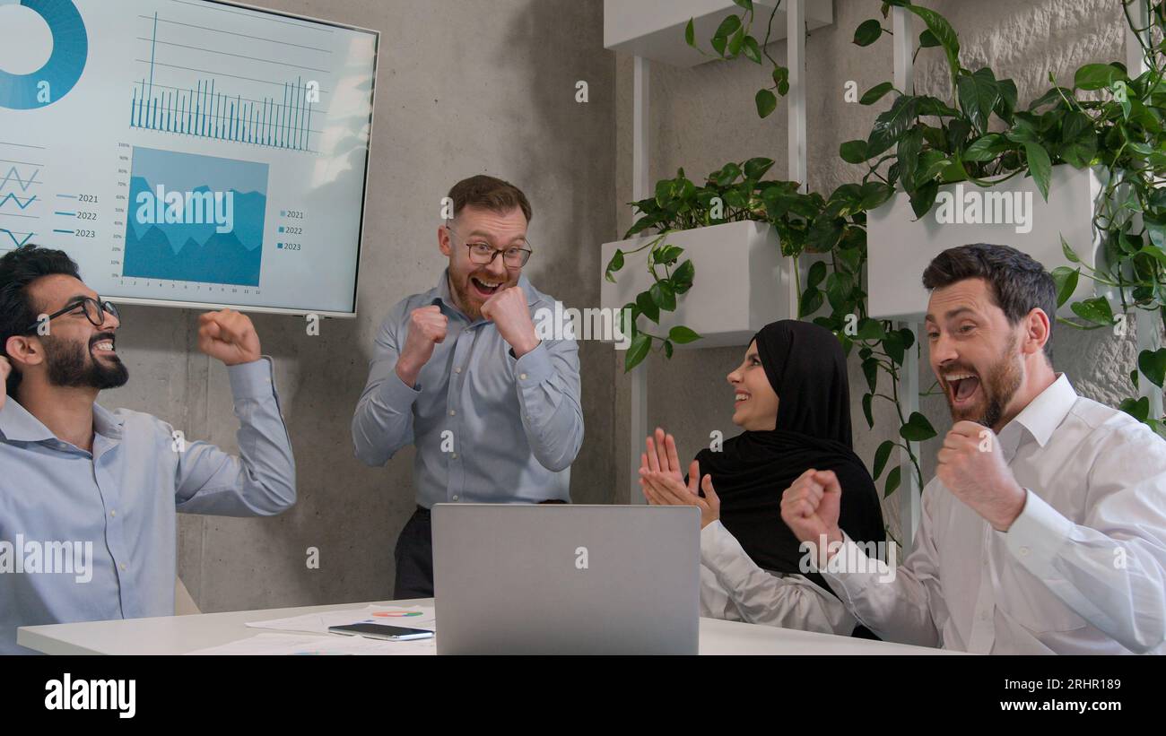 Happy multiethnic business colleagues celebrating laptop win success ...