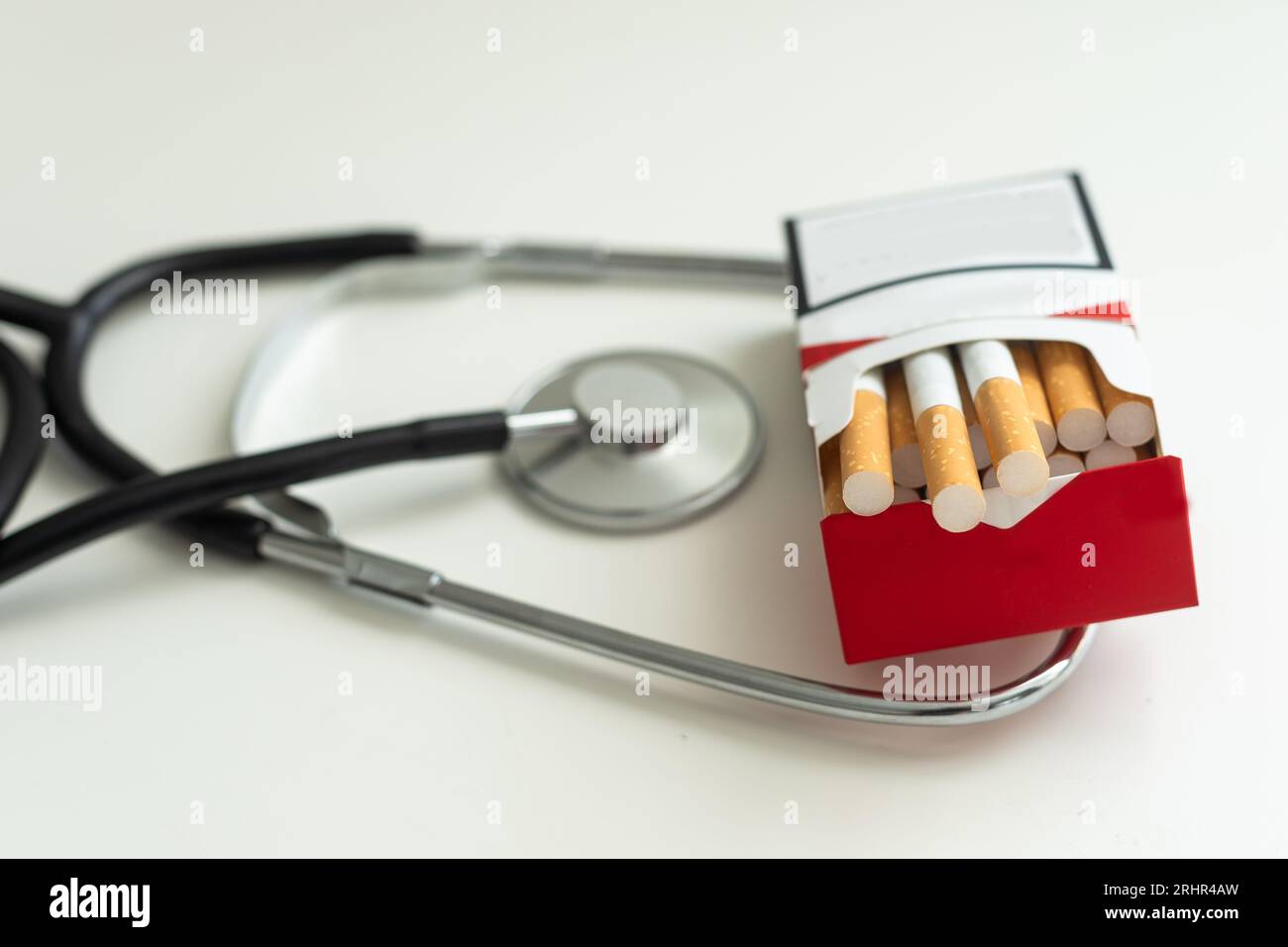 Cigarettes in a first aid tin with stethoscope on a white background ...