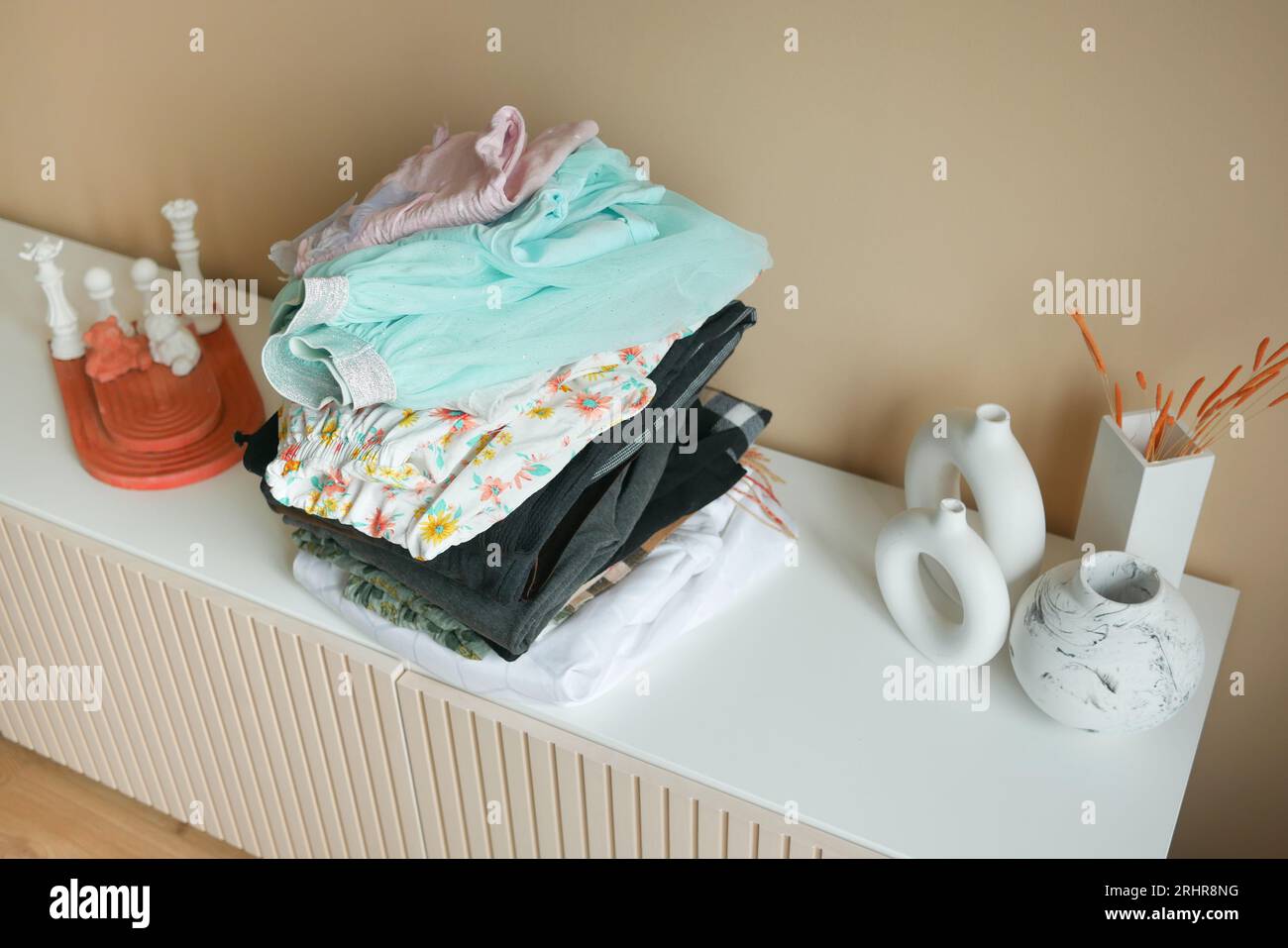 Stack of clothes on table indoor Stock Photo - Alamy
