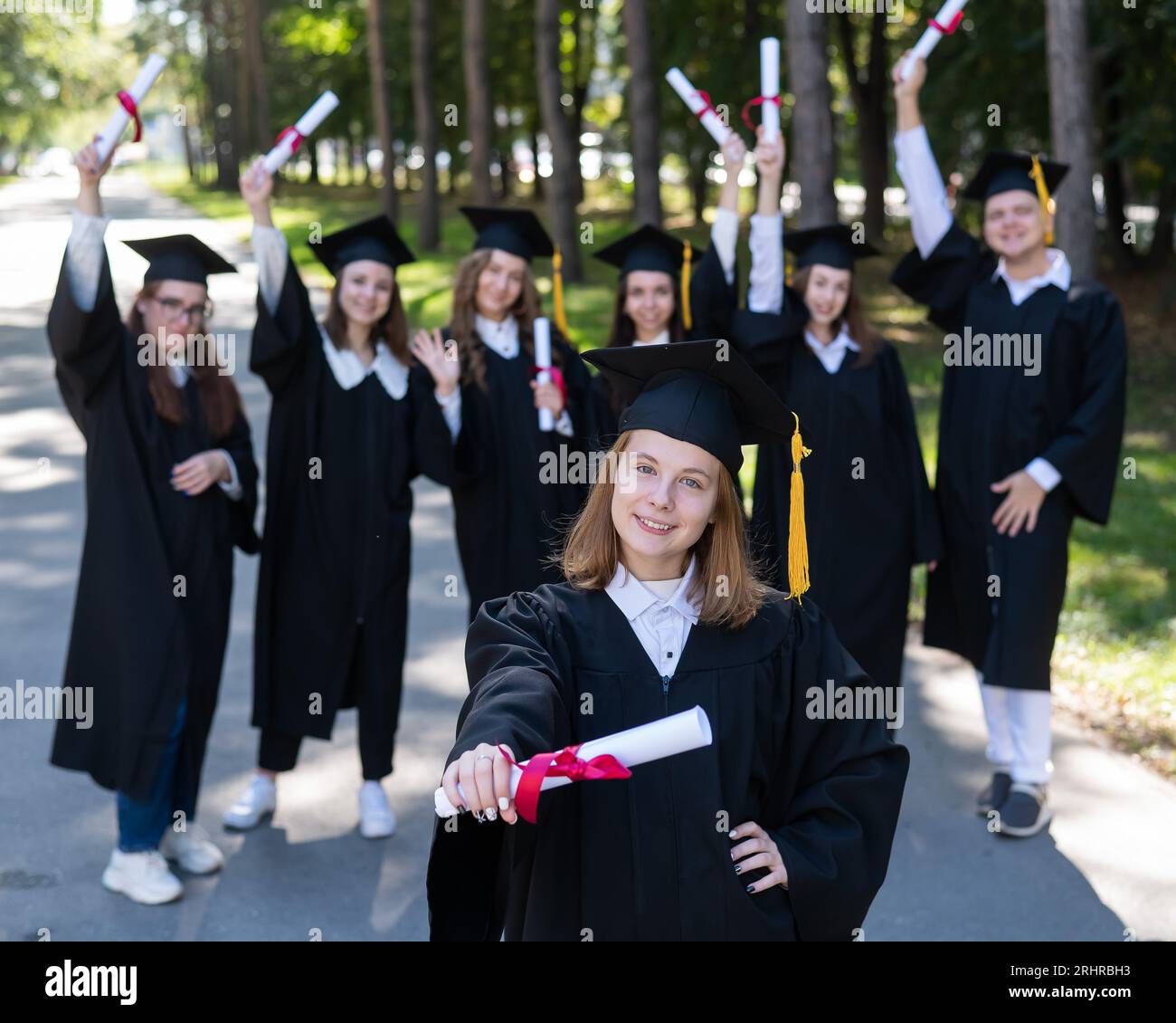 Happy young caucasian woman celebrating graduation with classmates. A ...