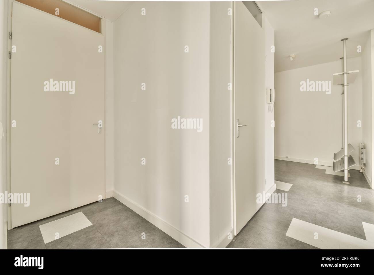 the inside of a room with white walls and grey flooring on the left ...