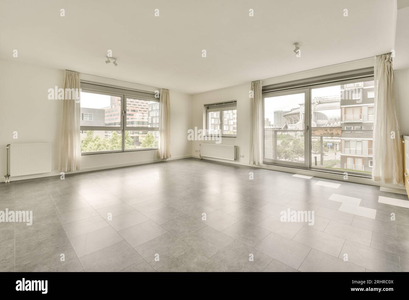 an empty living room with large windows and floor tiles on the floor ...