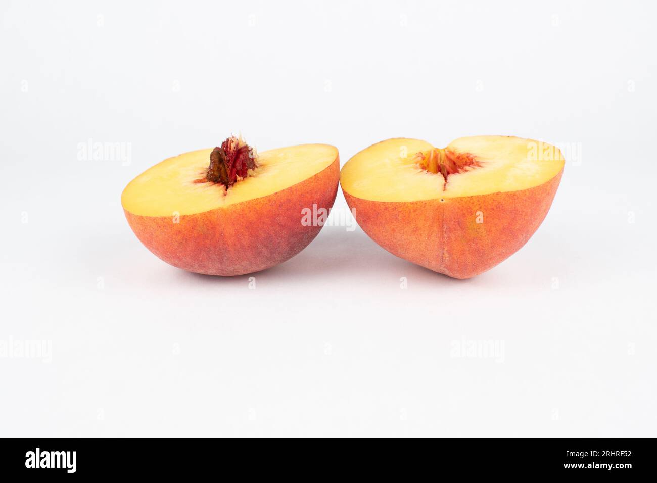Sliced half peach with pit white background Stock Photo - Alamy