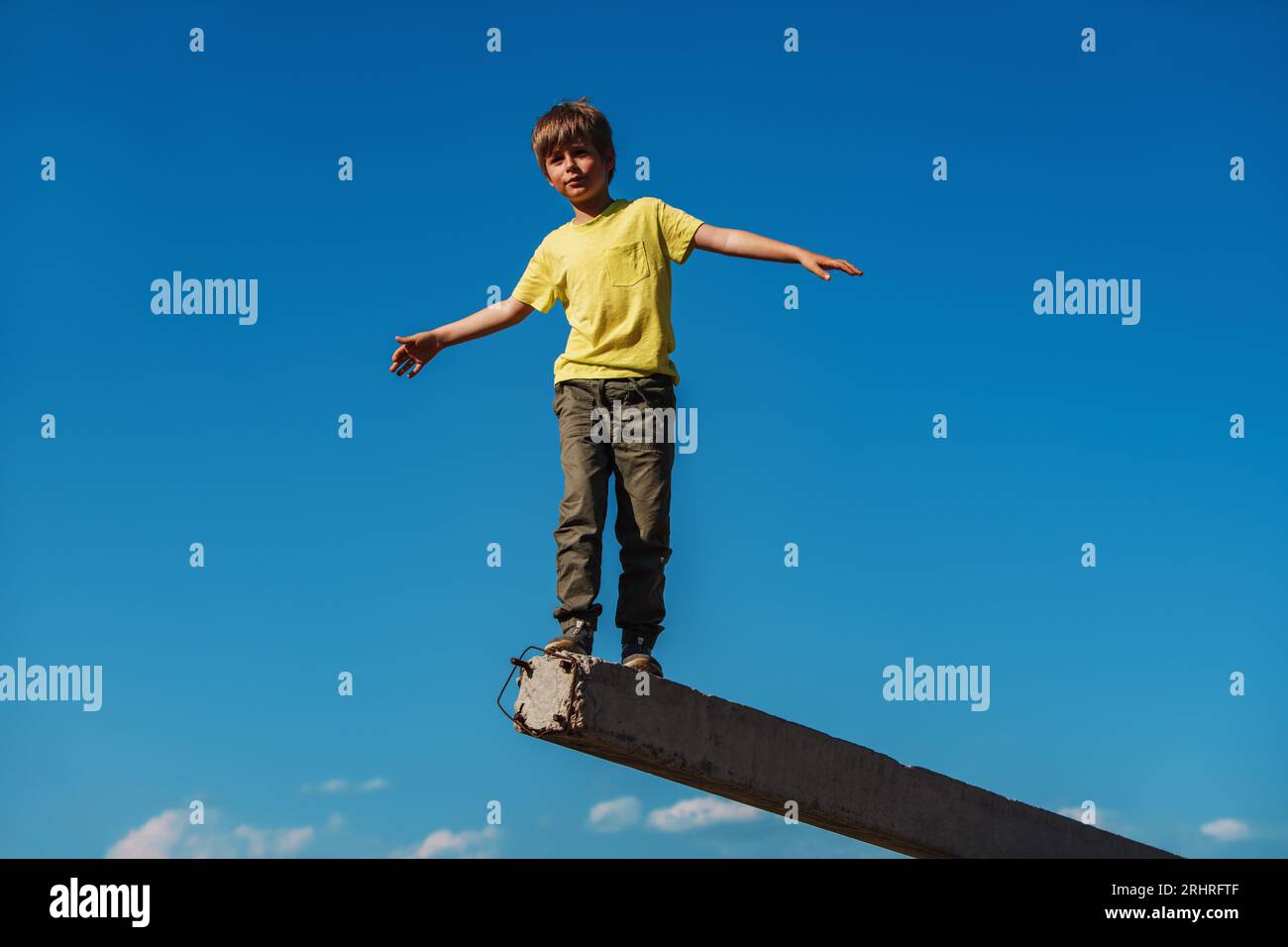 Boy walking and balancing on blue sky backgrounds Stock Photo - Alamy