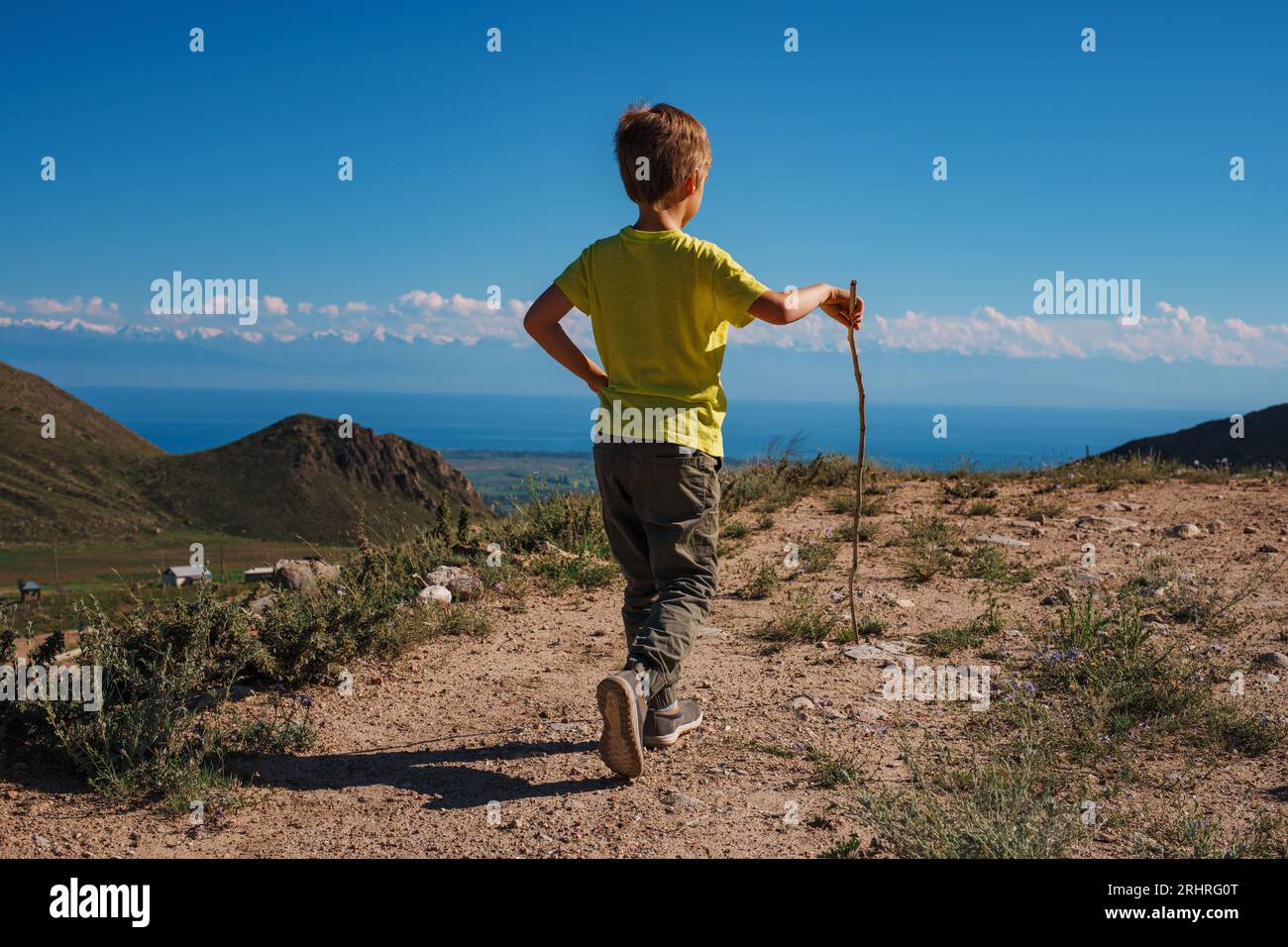 Boy hiker with stick walks on a mountain trail Stock Photo - Alamy