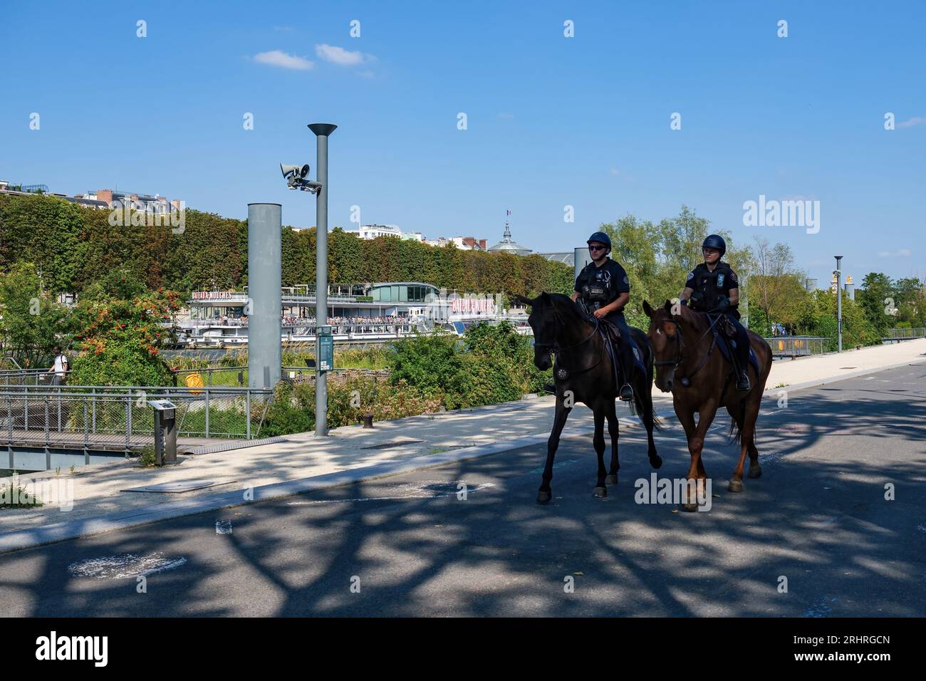 Mounted police officers on horses patrolling along the bank of the ... Mounted police officers on horses patrolling along the bank of the ...