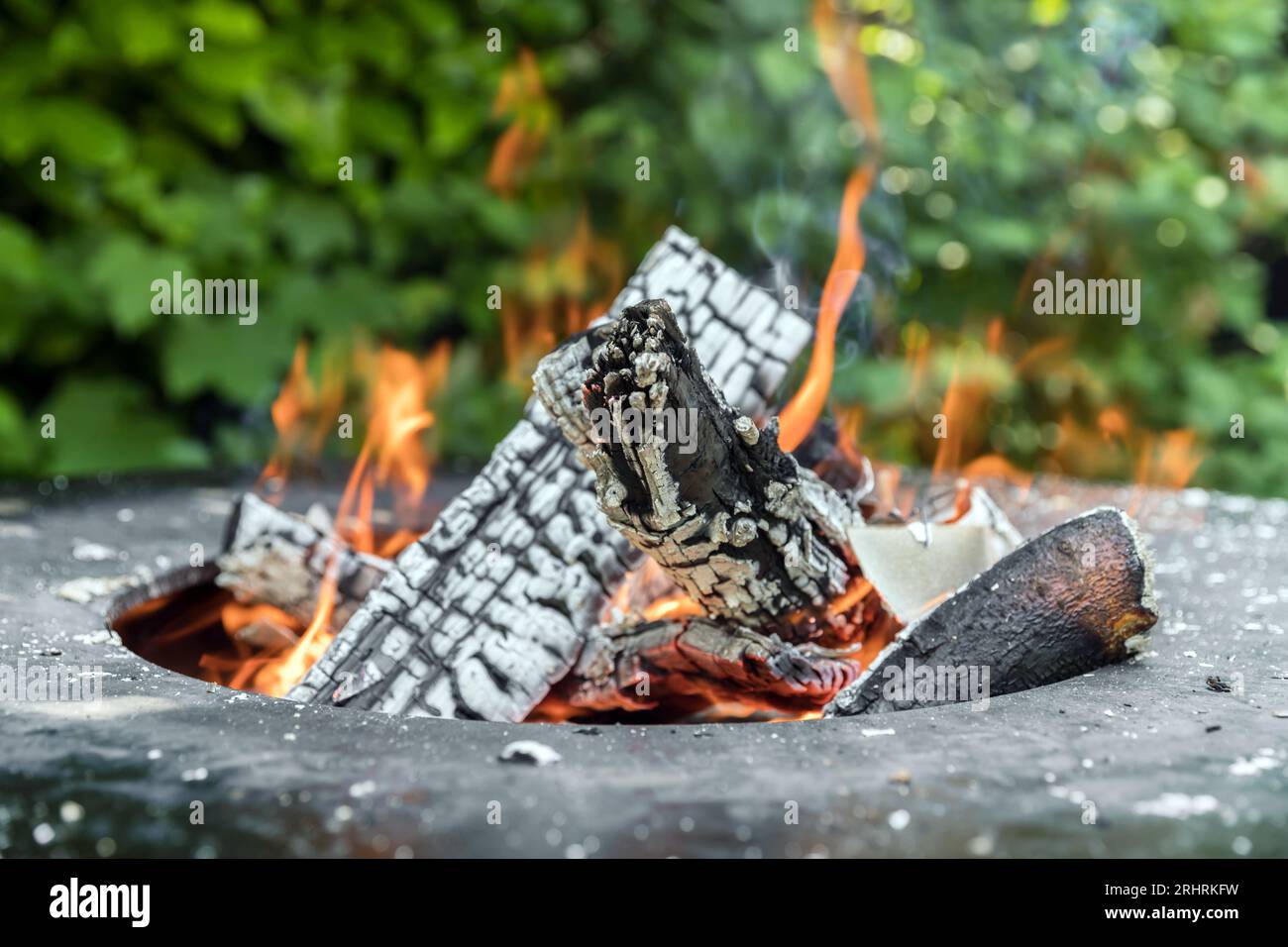 Close up shot of log pieces and fire wood, charcoal and ashes burning ...