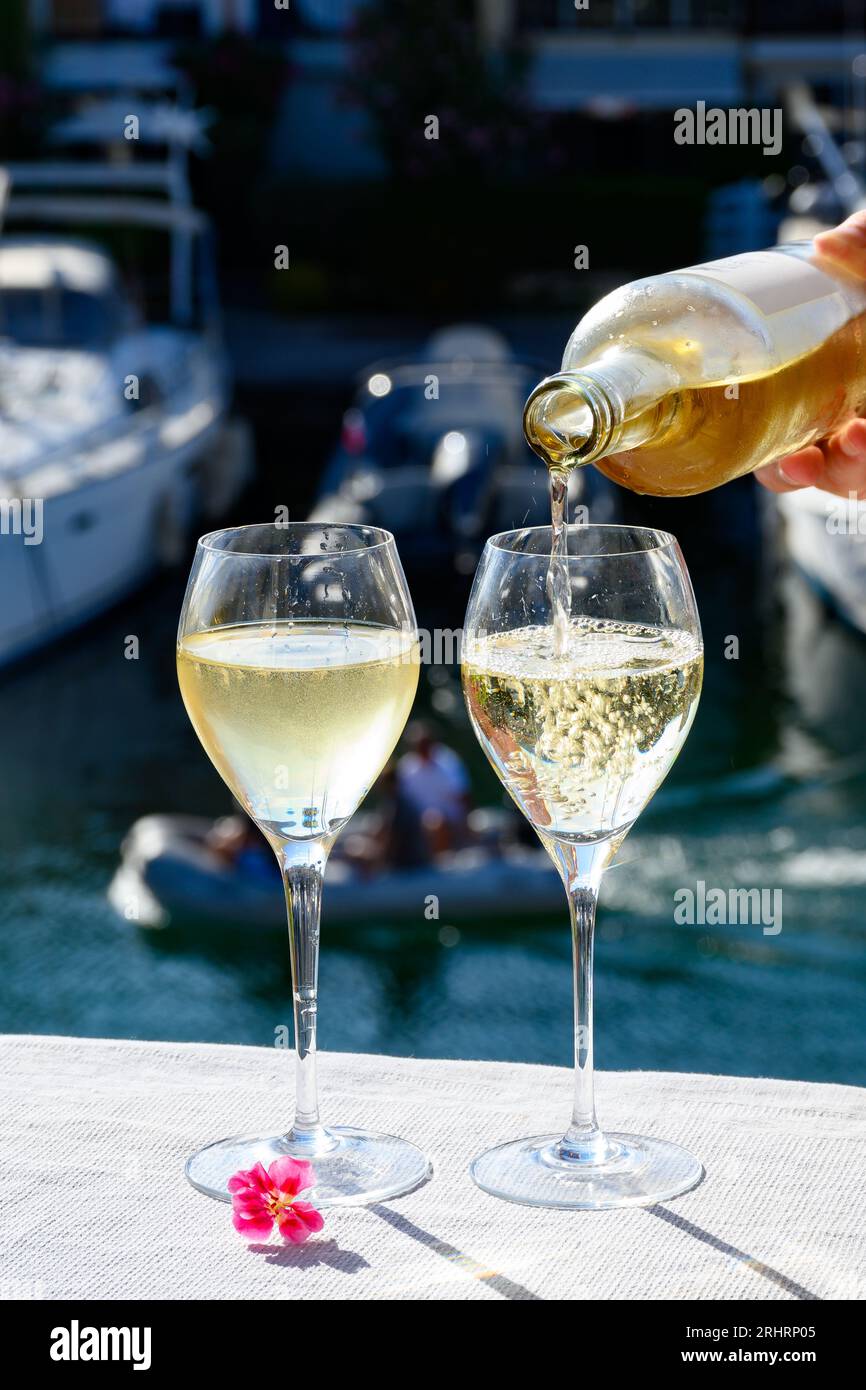 Glass of cold white wine in yacht harbour of Port Grimaud, summer ...