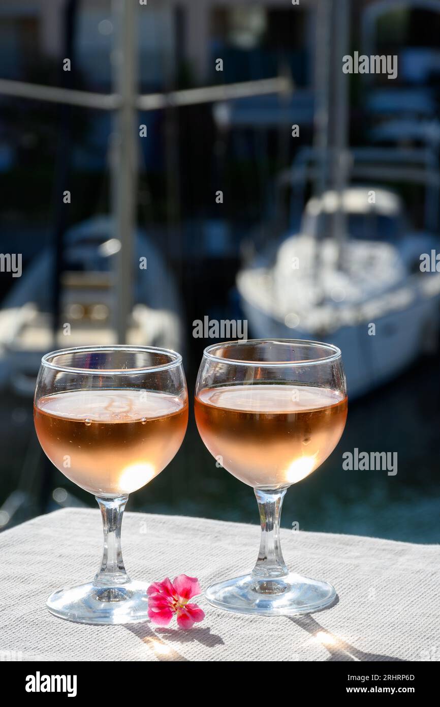 Glasses of cold rose Cote de Provence wine in yacht harbour of Port ...