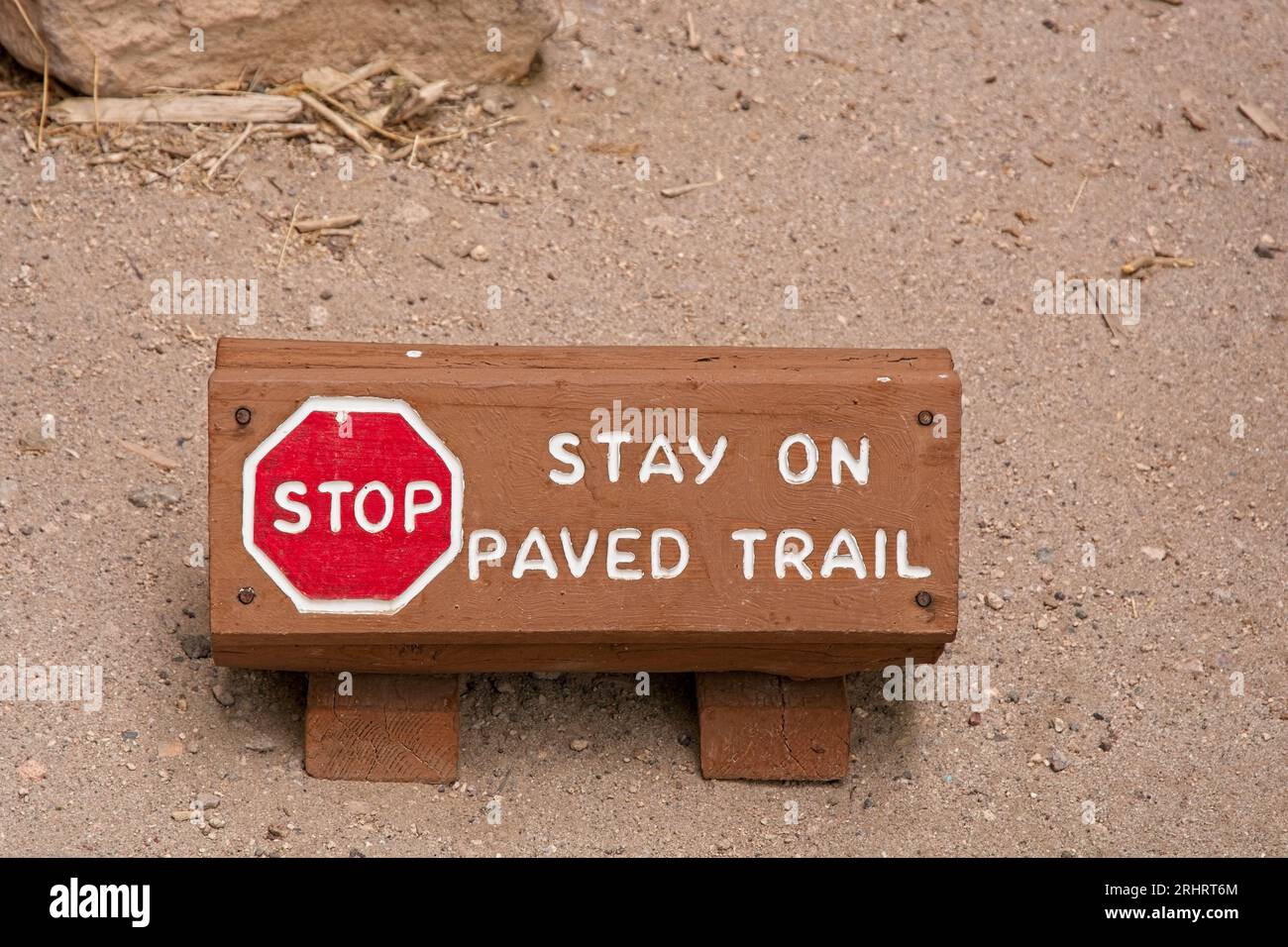 Wooden sign warning to stay on paved trail along Pueblo Loop Trail in ...