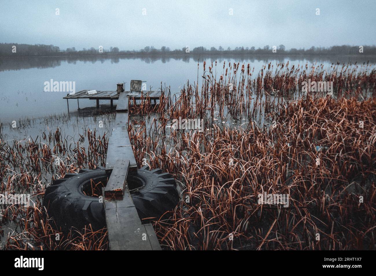 An old boat dock in the lake. Autumn with fog over the water and movie ...