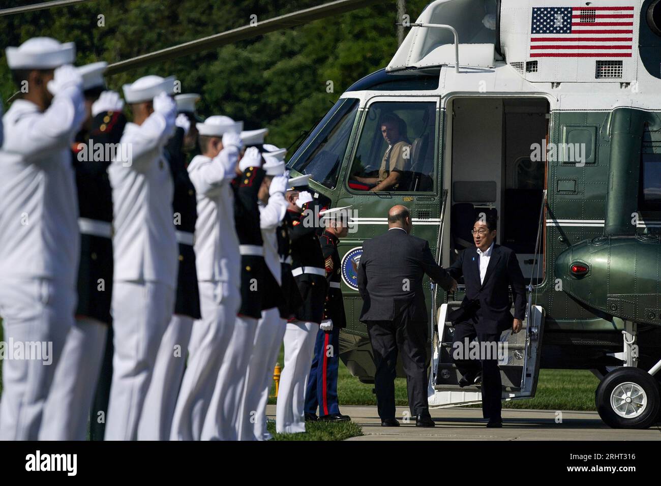 Japanese Prime Minister Fumio Kishida is greeted by Ethan Rosenzweig as ...