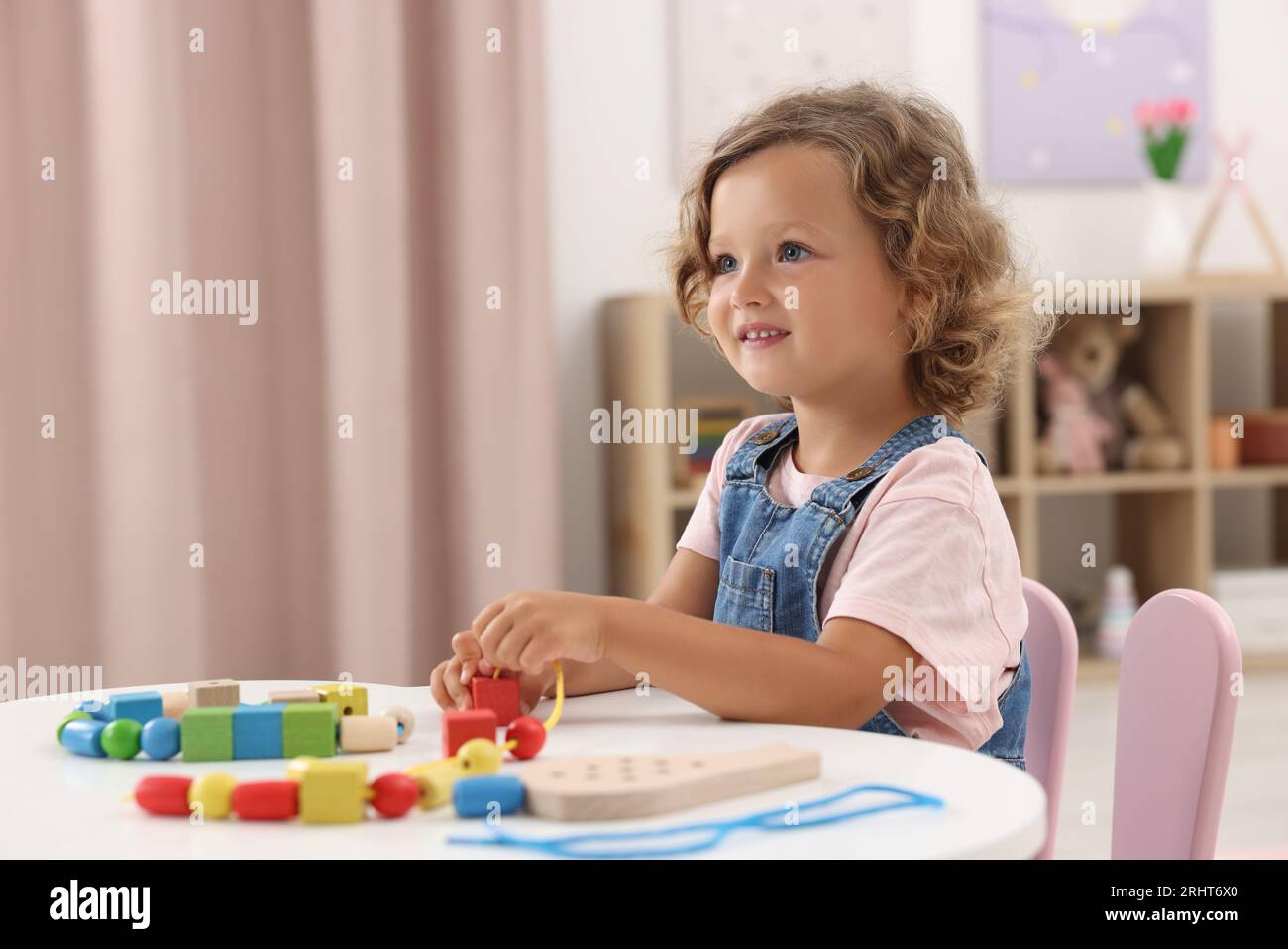 Motor skills development. Little girl playing with wooden pieces and ...