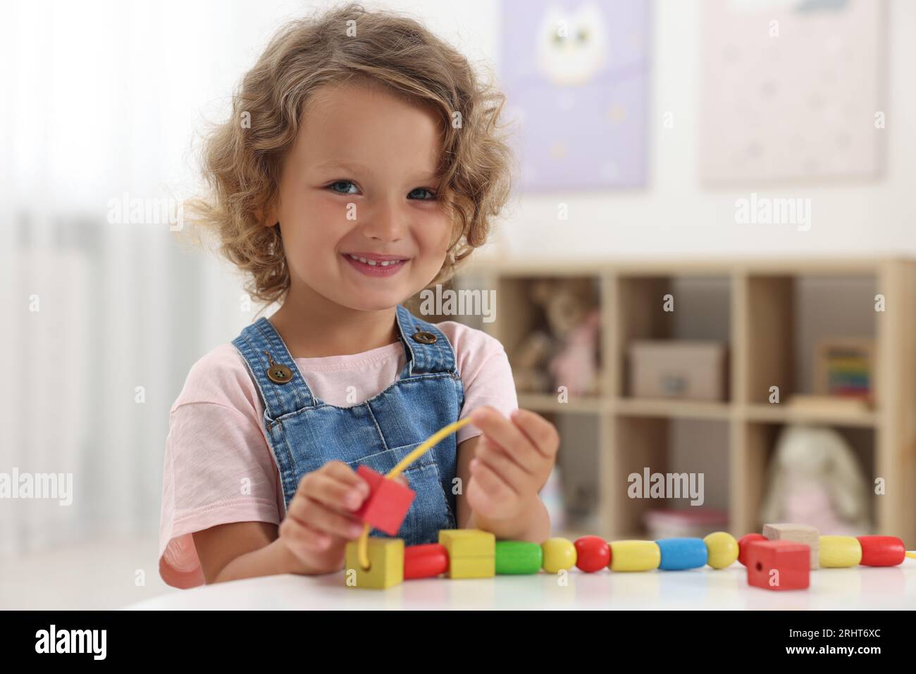Motor skills development. Little girl playing with wooden pieces and ...