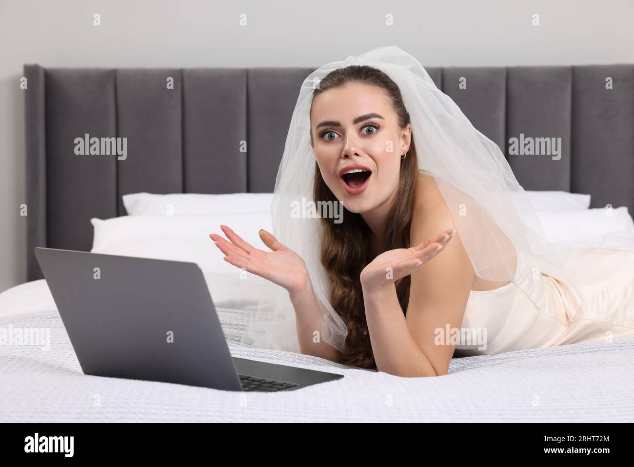 Shocked bride with laptop on bed in bedroom Stock Photo - Alamy