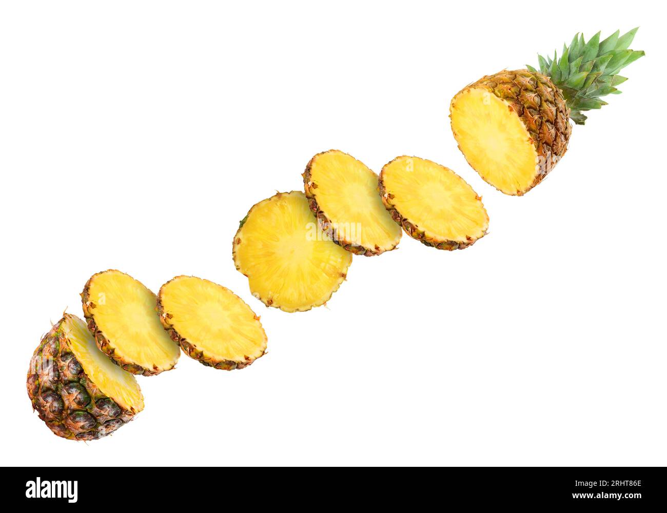Slices of juicy pineapple flying between its top and bottom on white ...
