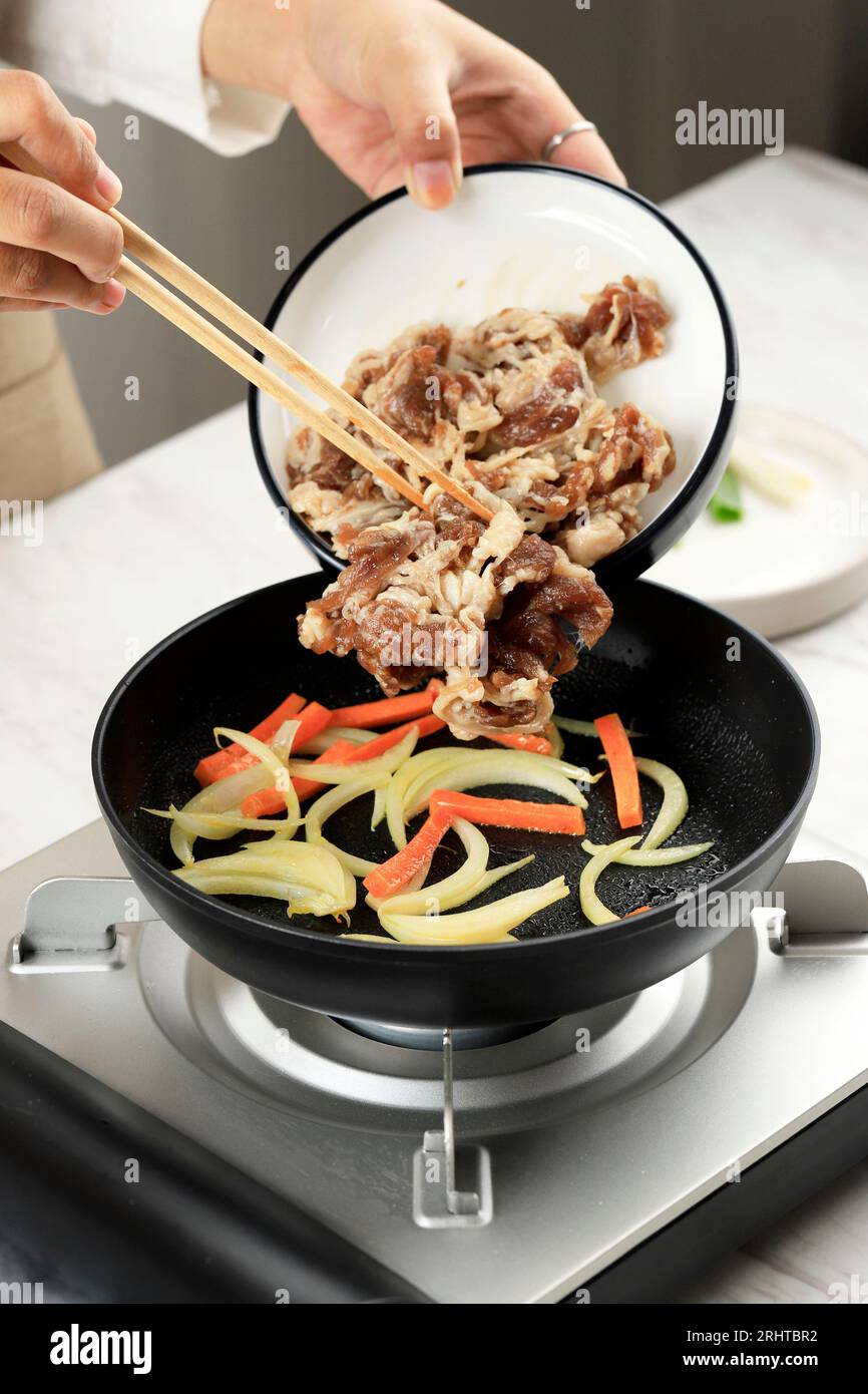 Female Hand Cooking Korean Bulgogi Meat, Put Raw Slice Beef to The Pan ...