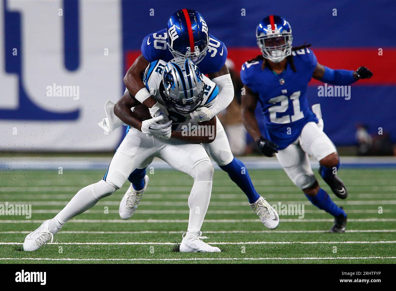 New York Giants' Darnay Holmes (30), top, tackles Carolina Panthers ...