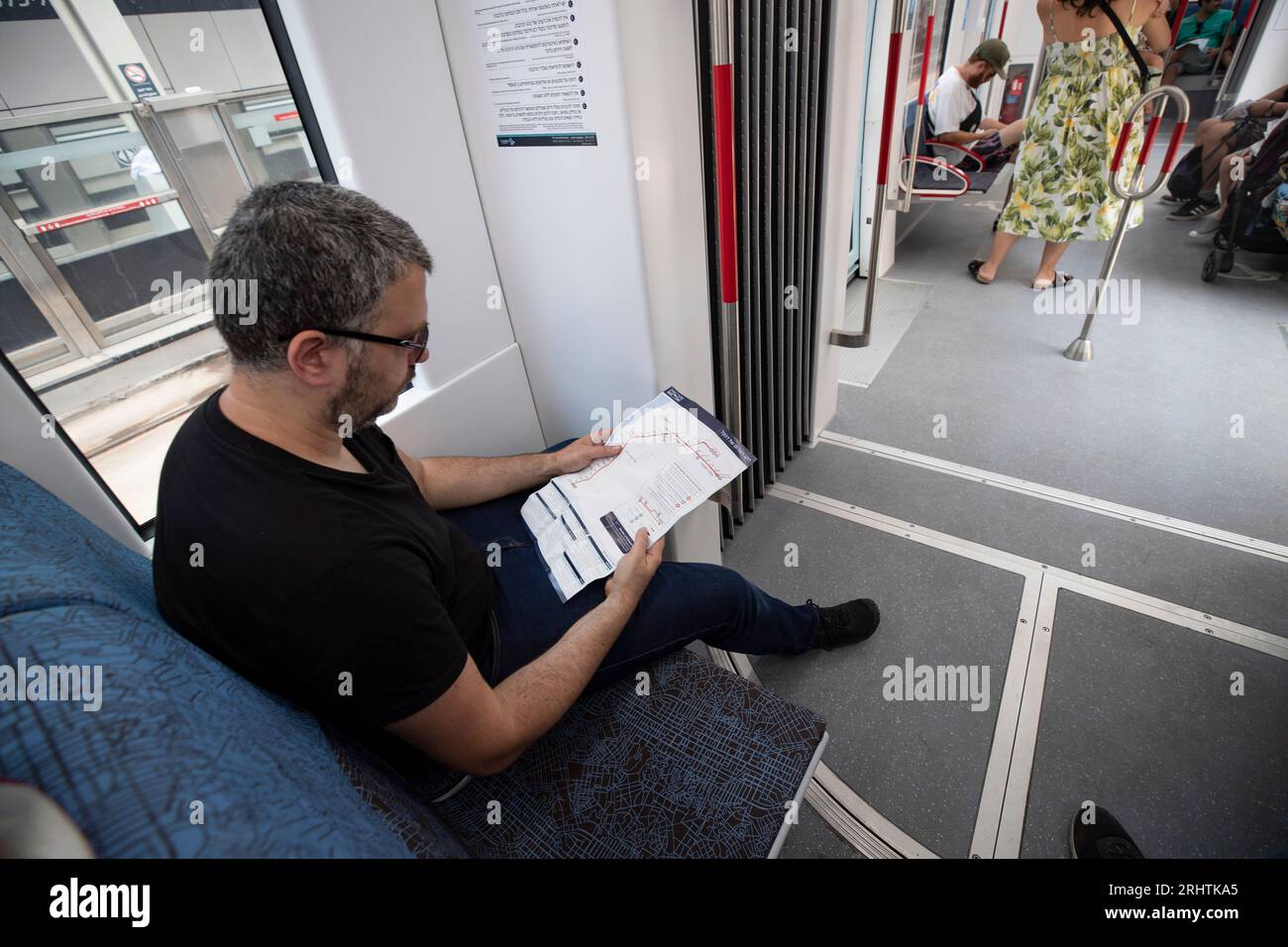 Tel Aviv. 18th Aug, 2023. A passenger checks a route map aboard a train ...