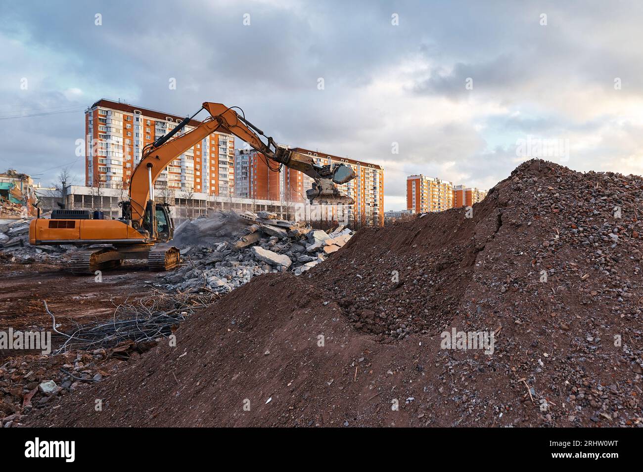 Excavator with hydraulic press breaks concrete leftovers Stock Photo - Alamy