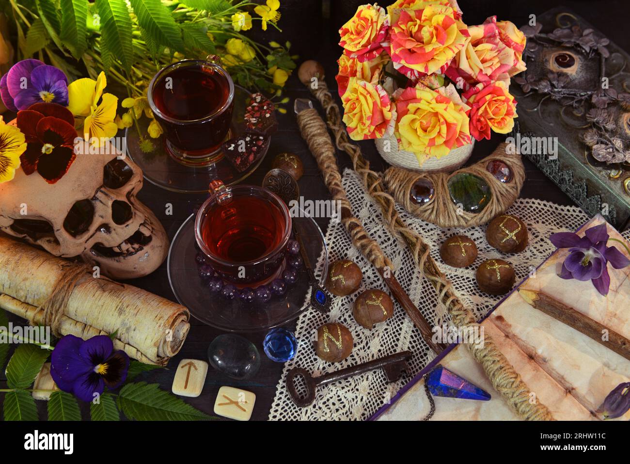Still life with manuscript, skull, runes and flowers on witch ritual ...