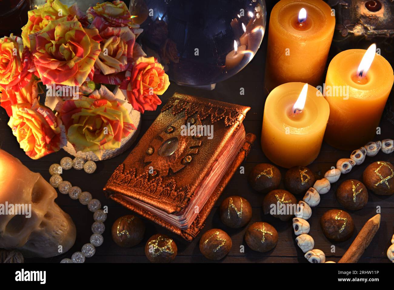 Still life with magic book of spells, burning candles and runes on ...