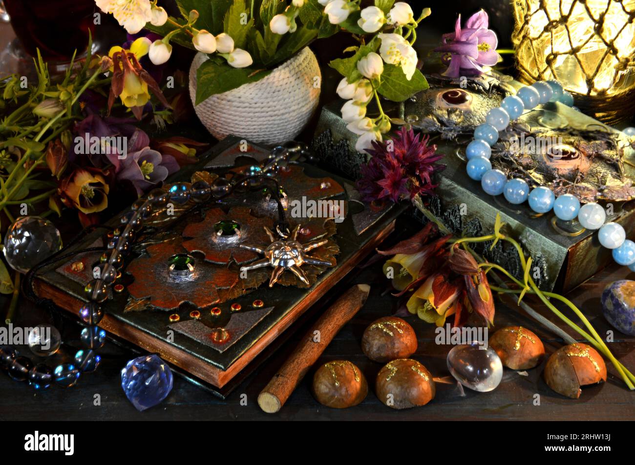 Still life with magic book of spells, runes and flowers on ritual table ...