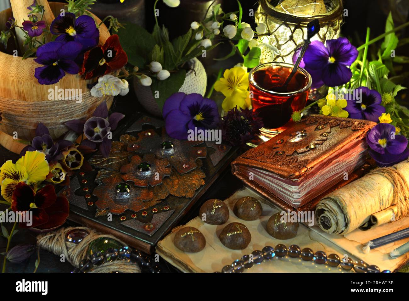 Still life with runes, magic book of spells and paper scrolls on witch ...