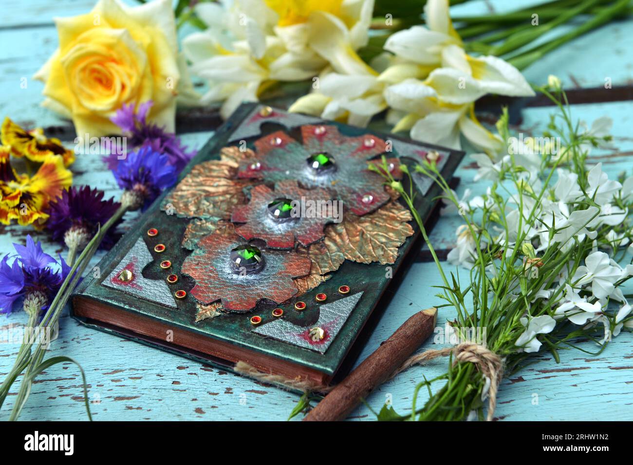 Still life with beautiful flowers and magic book of spells or diary ...