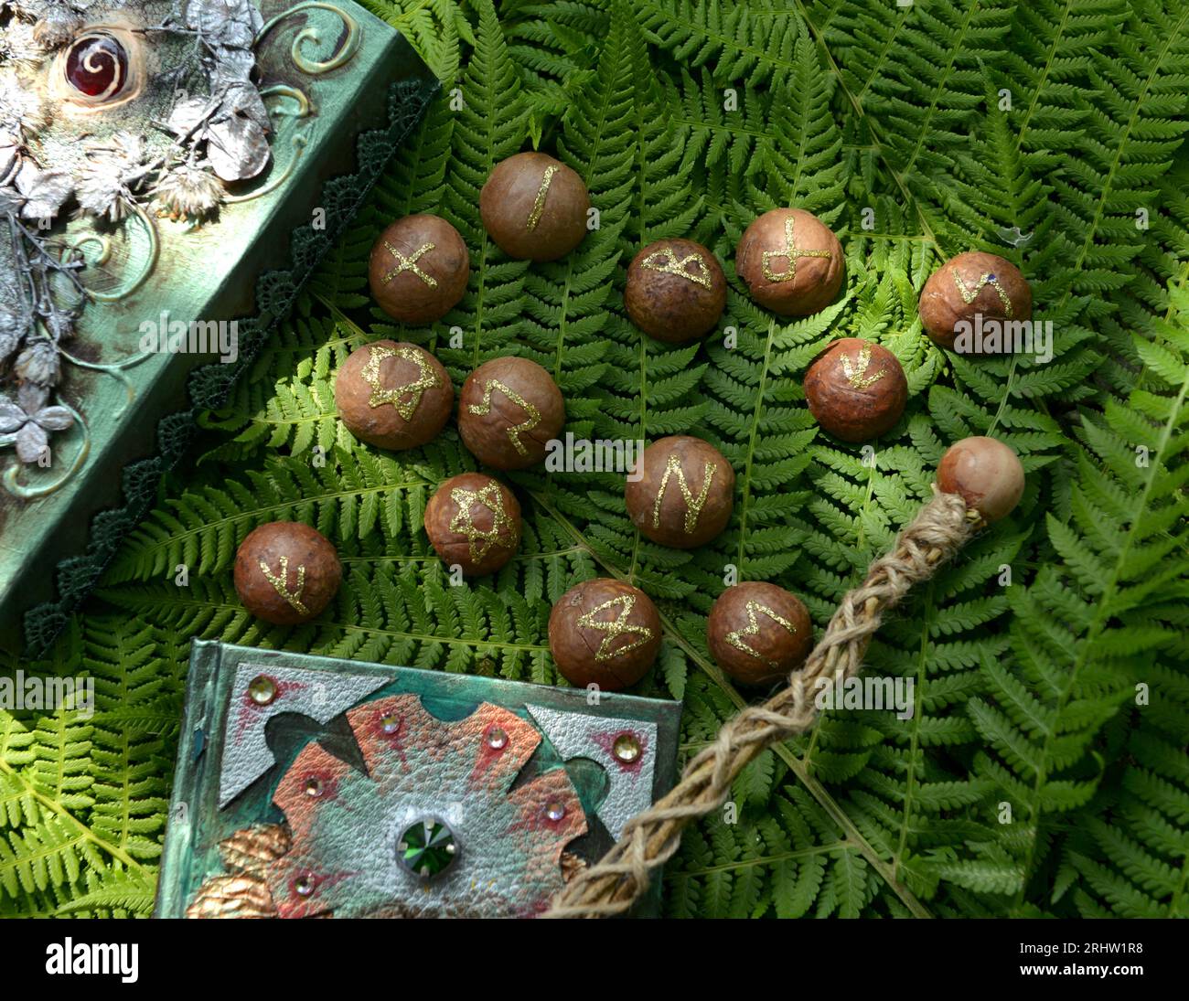 Still life with old wooden runes and magic book of spells against green ...