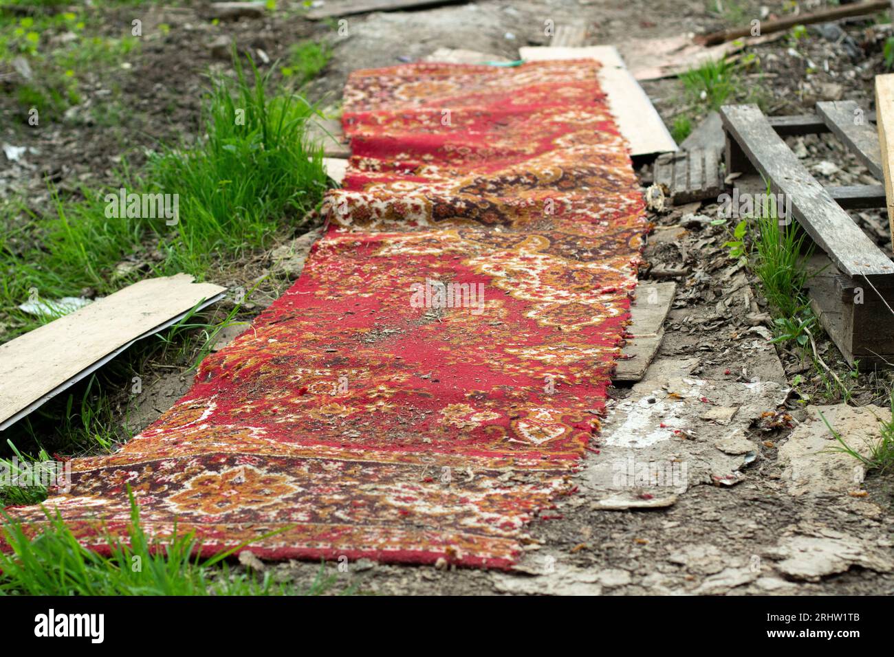 Red carpet on road in countryside. Path in village. Carpet. Dirty place ...