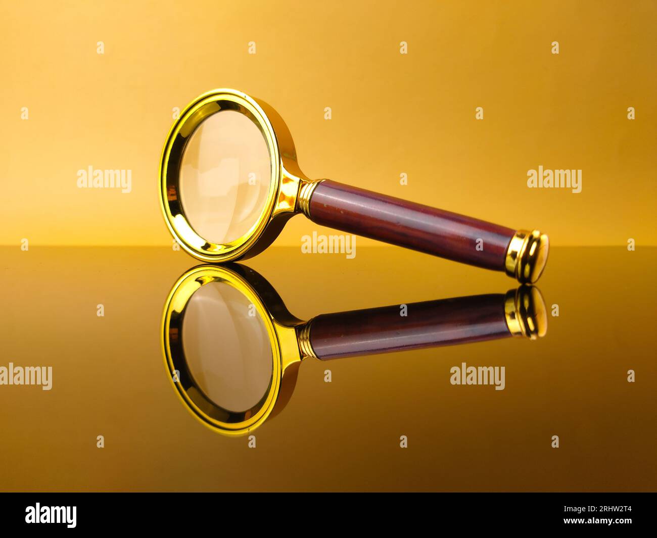 Vintage magnifying glass on yellow background with reflection on a ...