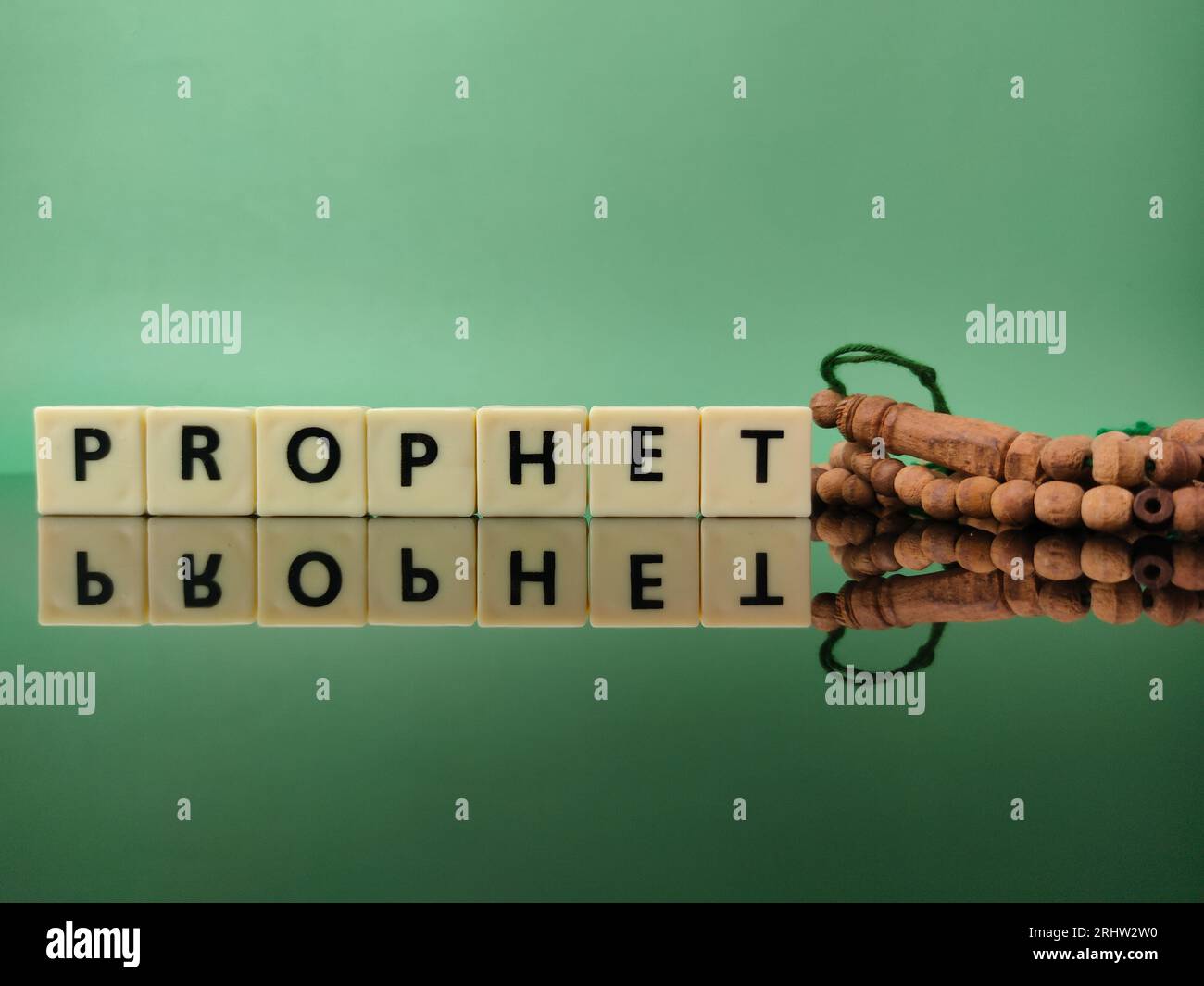 Toy word and tasbih prayer beads with text PROPHET on green background ...