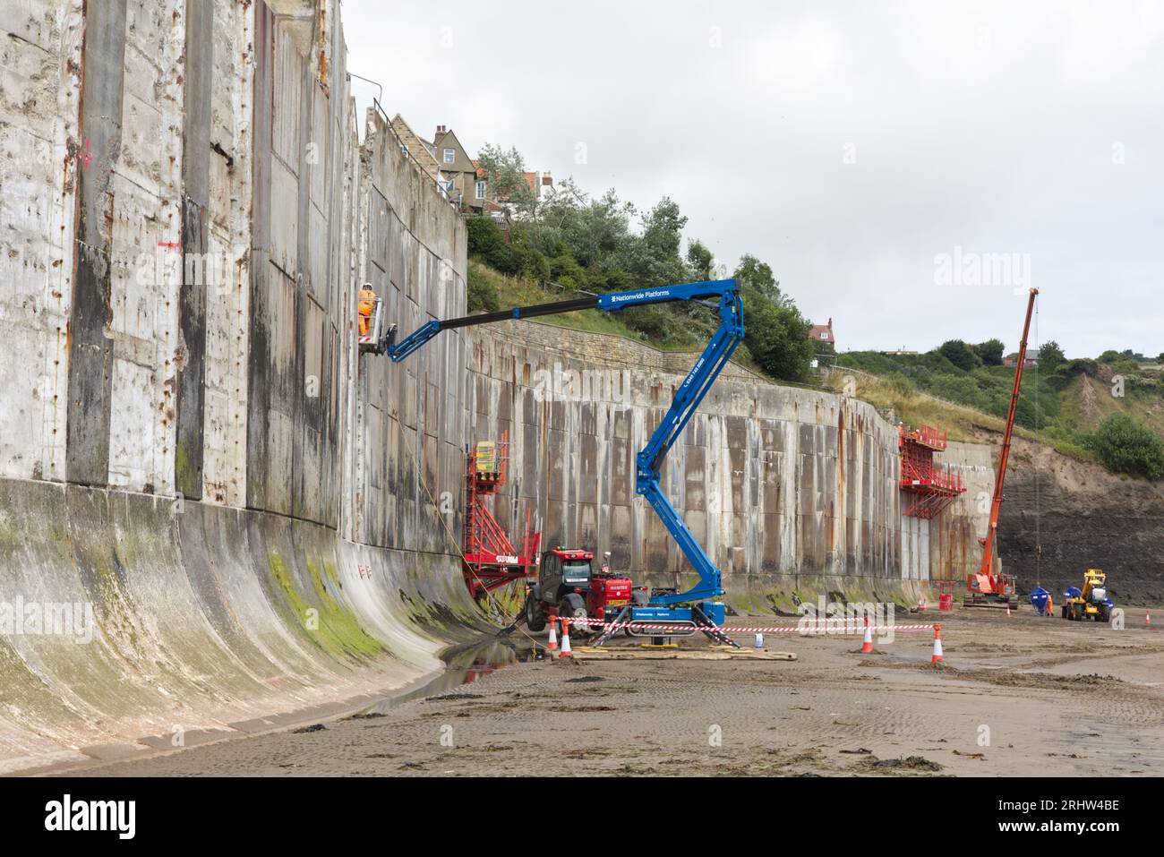 working on the sea wall at robin hoods bay yorkshire beach Stock Photo ...