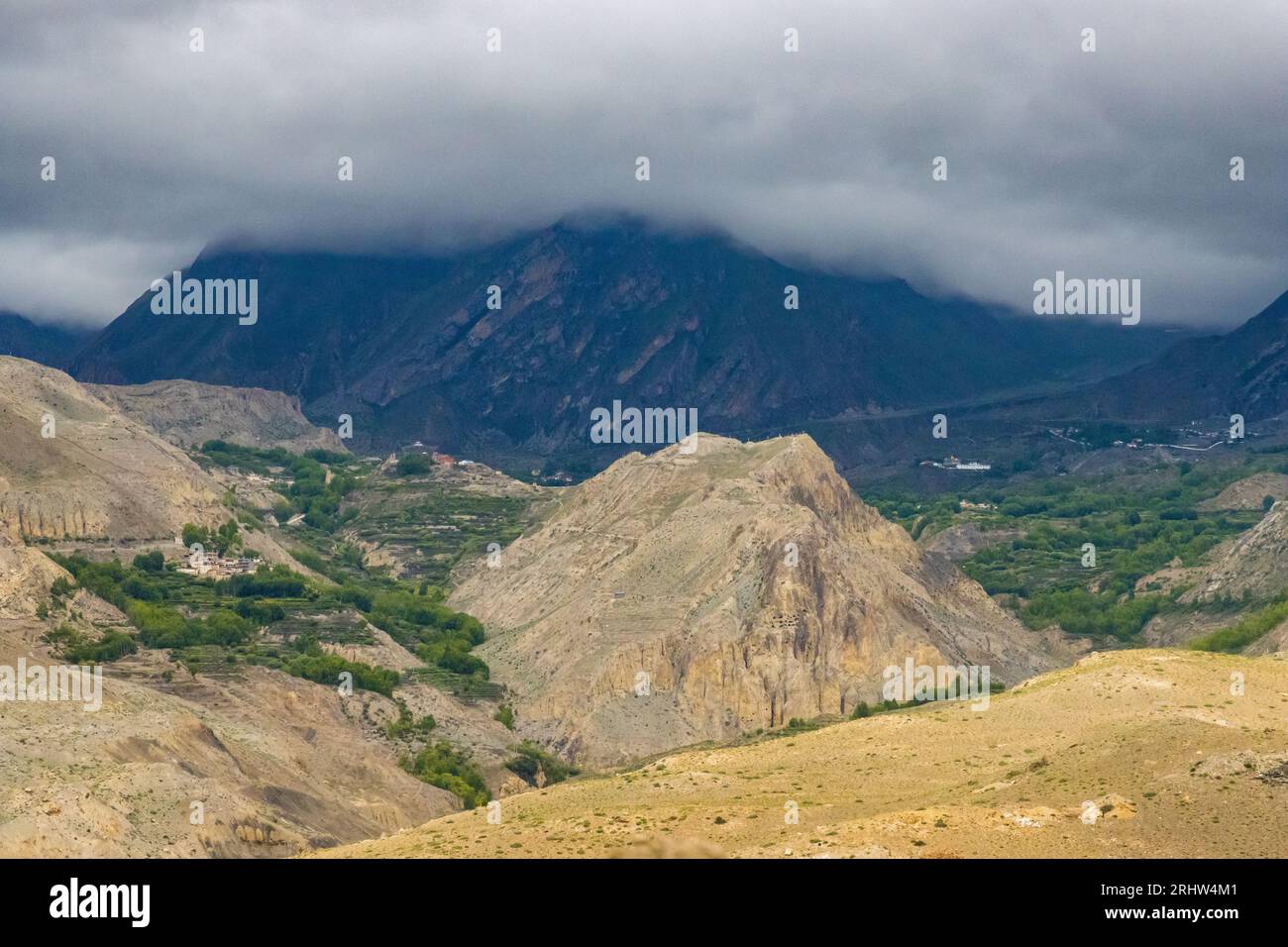 Dark Dramatic Desert Landscape with Foggy Mountains and Distant Houses ...