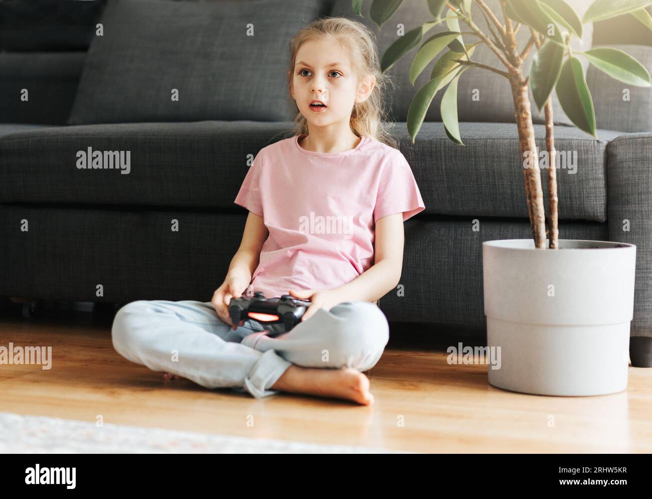 A little girl is playing with a game console at home Stock Photo - Alamy