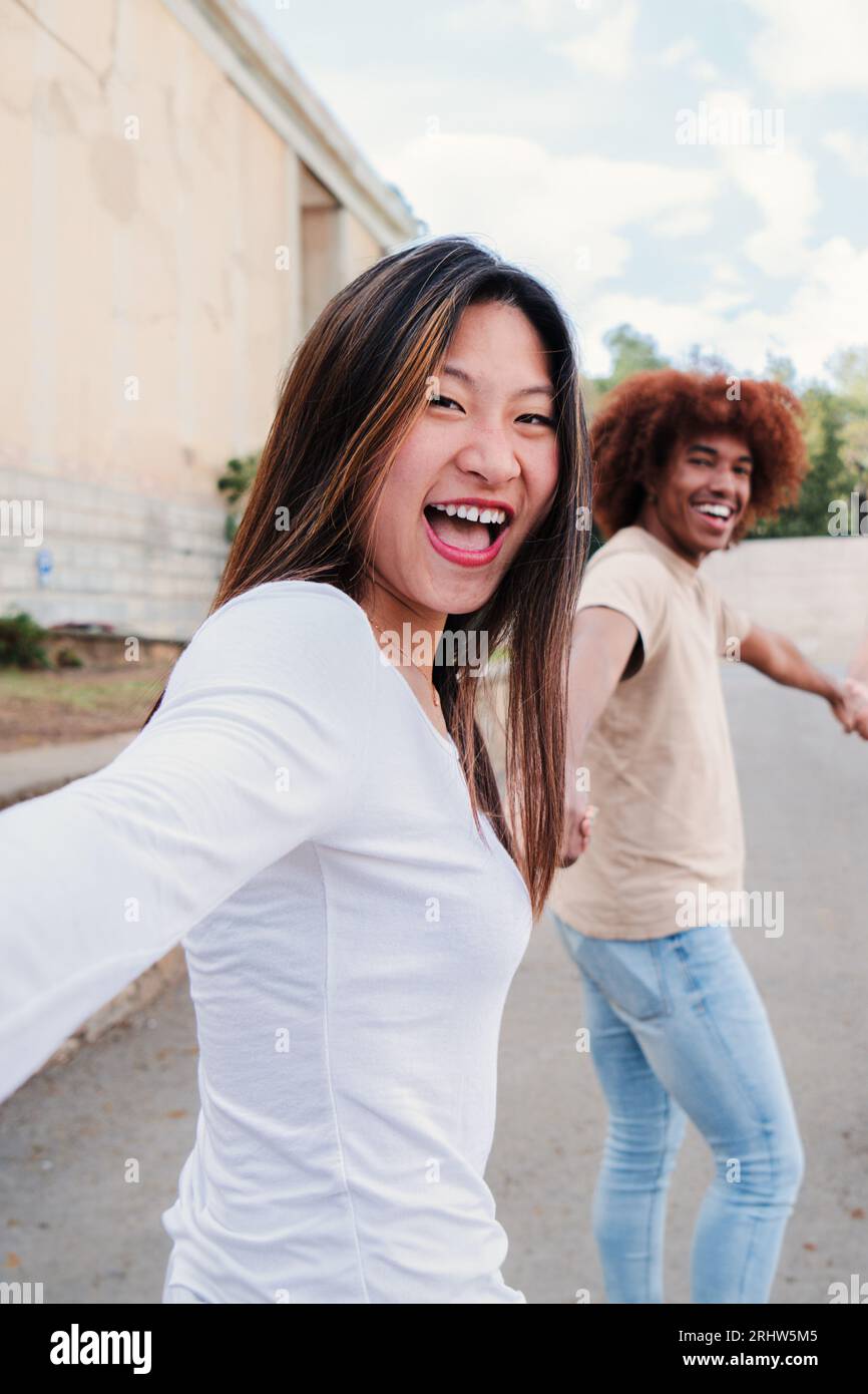 Vertical point view portrait of a multiracial group of friends walking ...