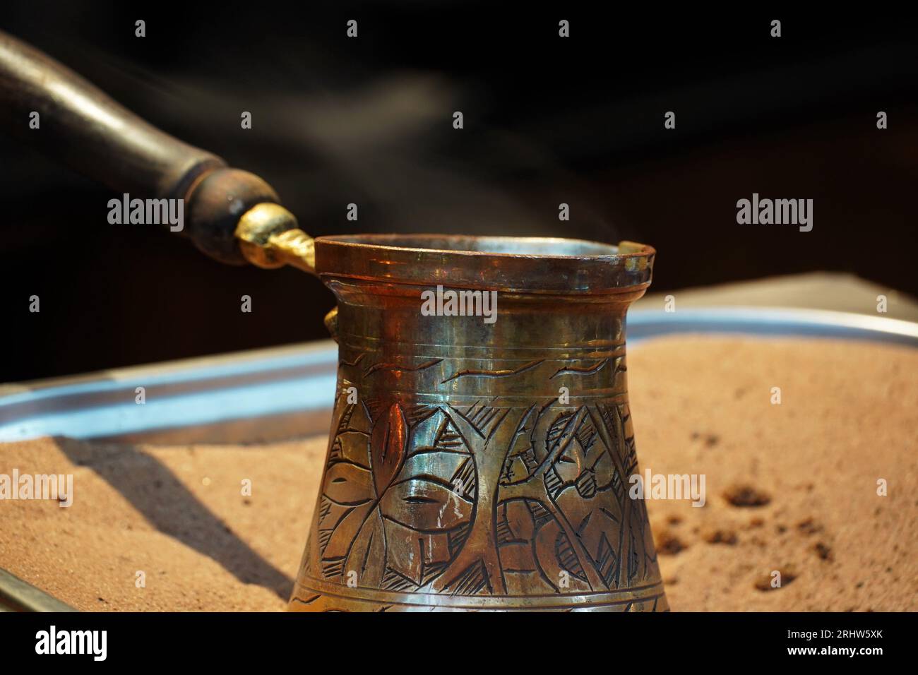 Traditional Turkish coffee in metal cezve, with hot sand. Copper ...