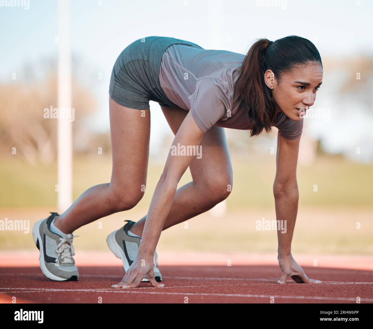 Woman, fitness and running start in athletics, motivation or competition on stadium or olympic ...