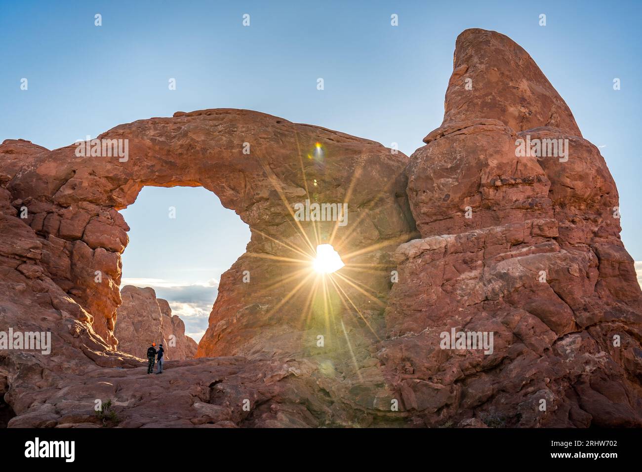 hiker enjoying the warm sun rays at turret arch in arches national park ...