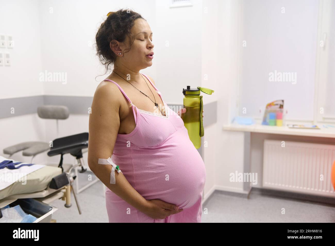 A woman in labor deep breathing to soothe the pain while having ...