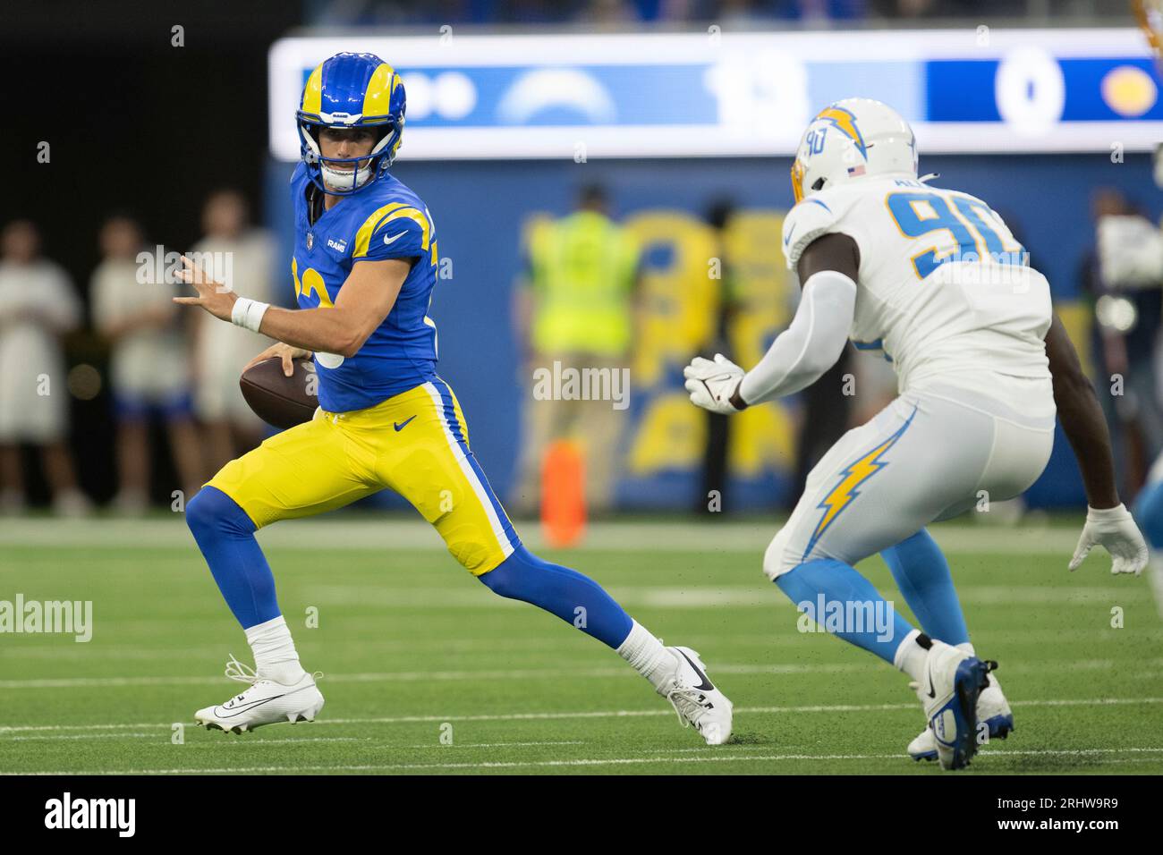 Los Angeles Rams quarterback Stetson Bennett (13) runs away from Los Angeles Chargers linebacker ...