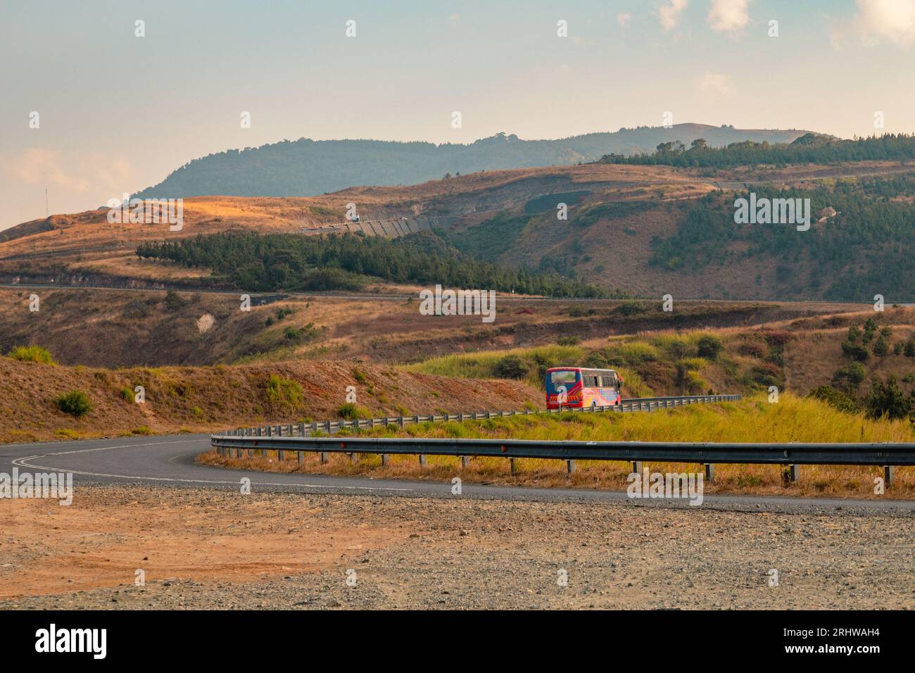 Scenic view of a public transport bus on meandering road on Mbeya ...