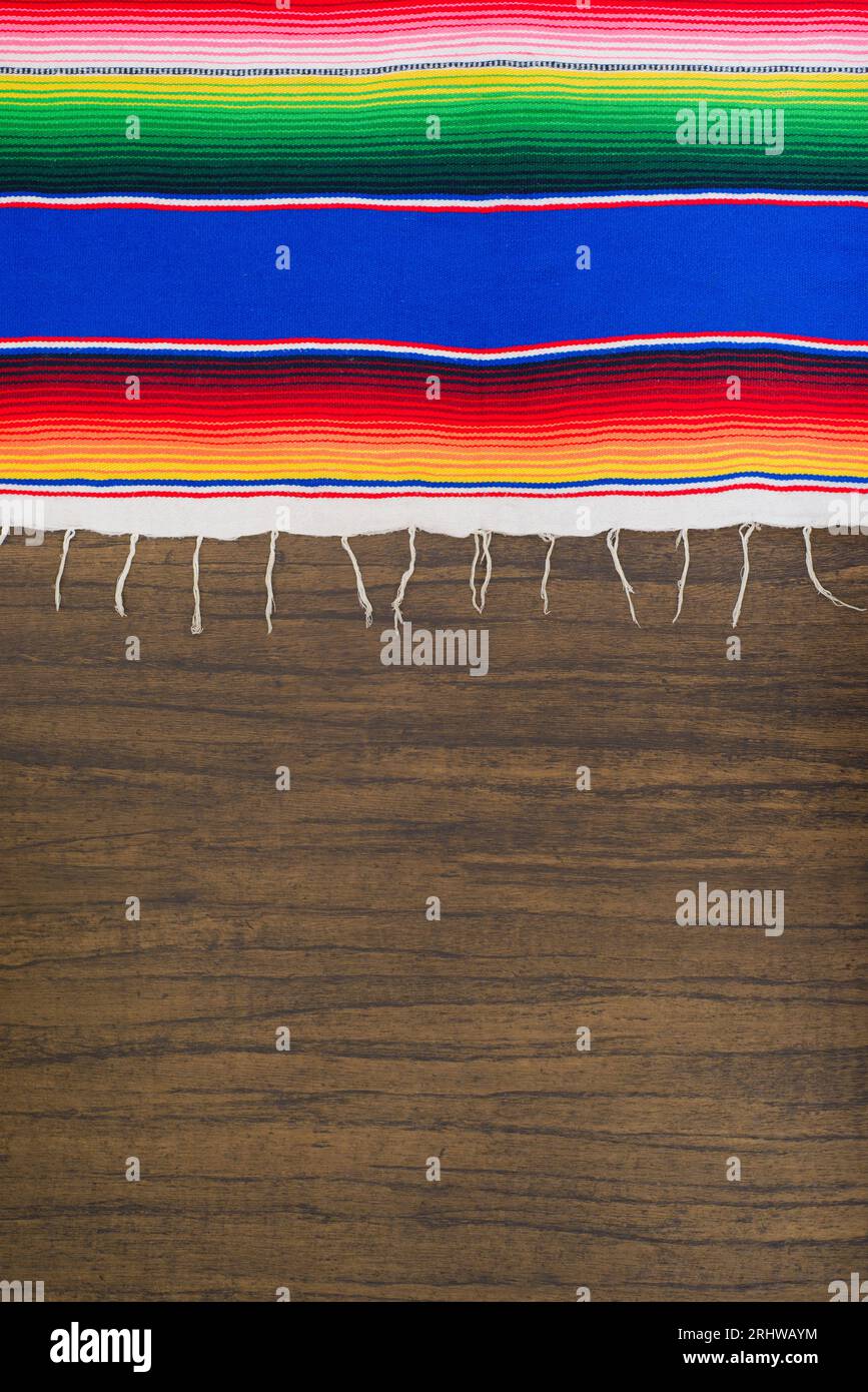 Colorful serape on wooden table. Typical colorful fabric from Mexico ...