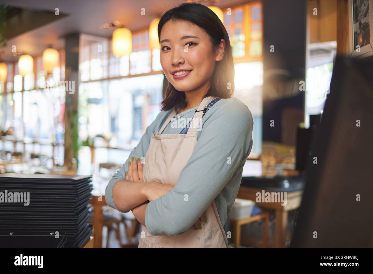 Waitress, portrait and Asian woman with arms crossed at cafe, coffee ...