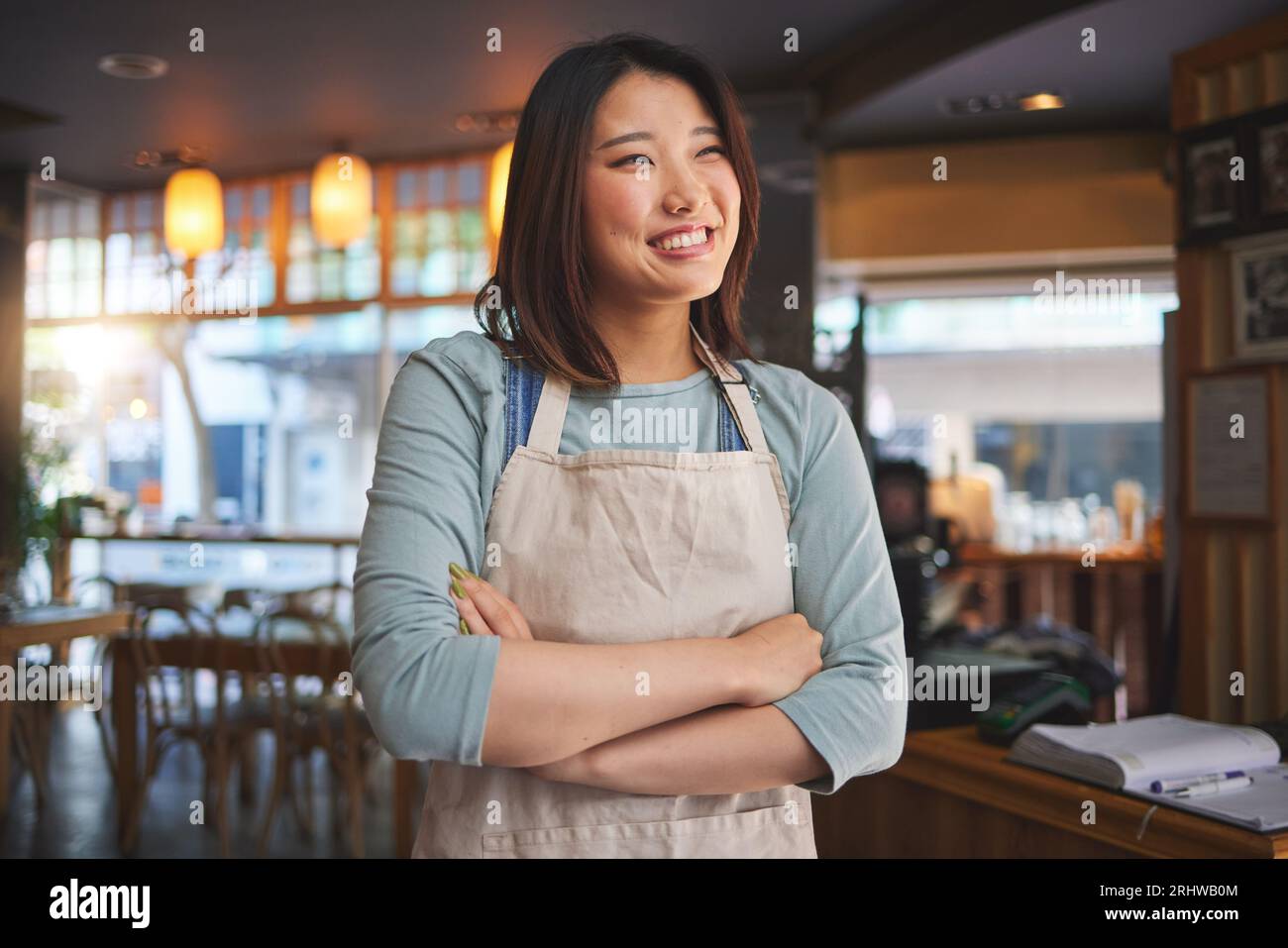Smile, thinking and arms crossed with an asian woman in a restaurant ...