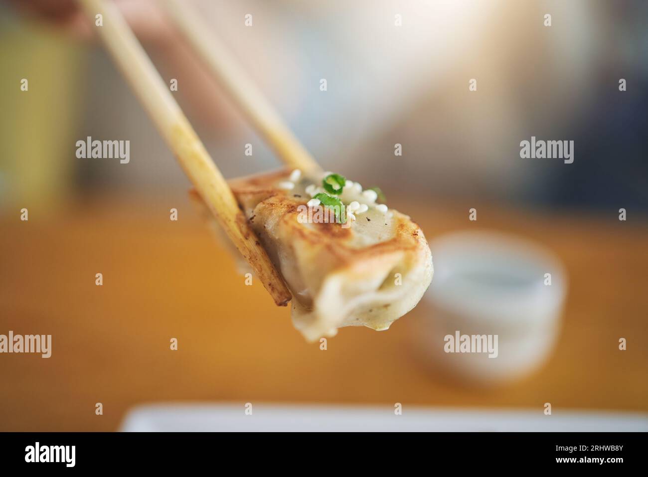 Closeup, protein and chopsticks with dumpling at a restaurant for food ...
